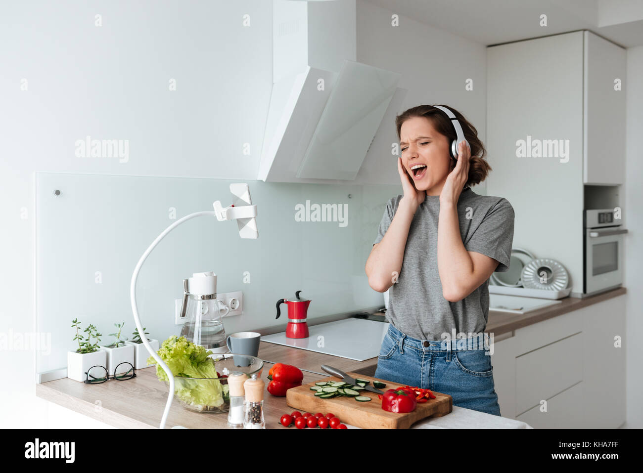 Portrait of a cheerful woman listening to music with headphones and ...