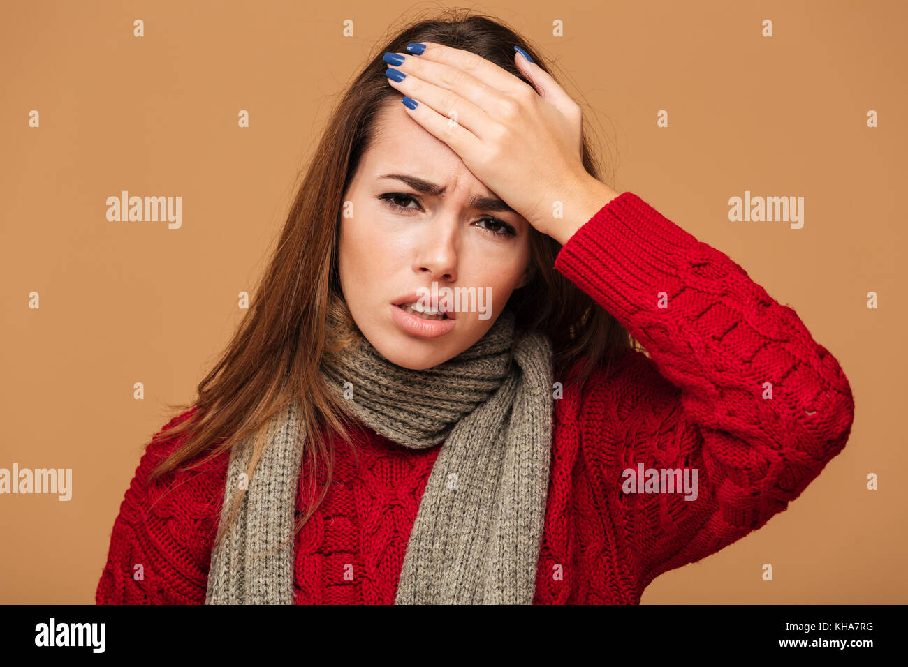 Close-up photo of unhealthy young caucasian woman touching her forehead ...
