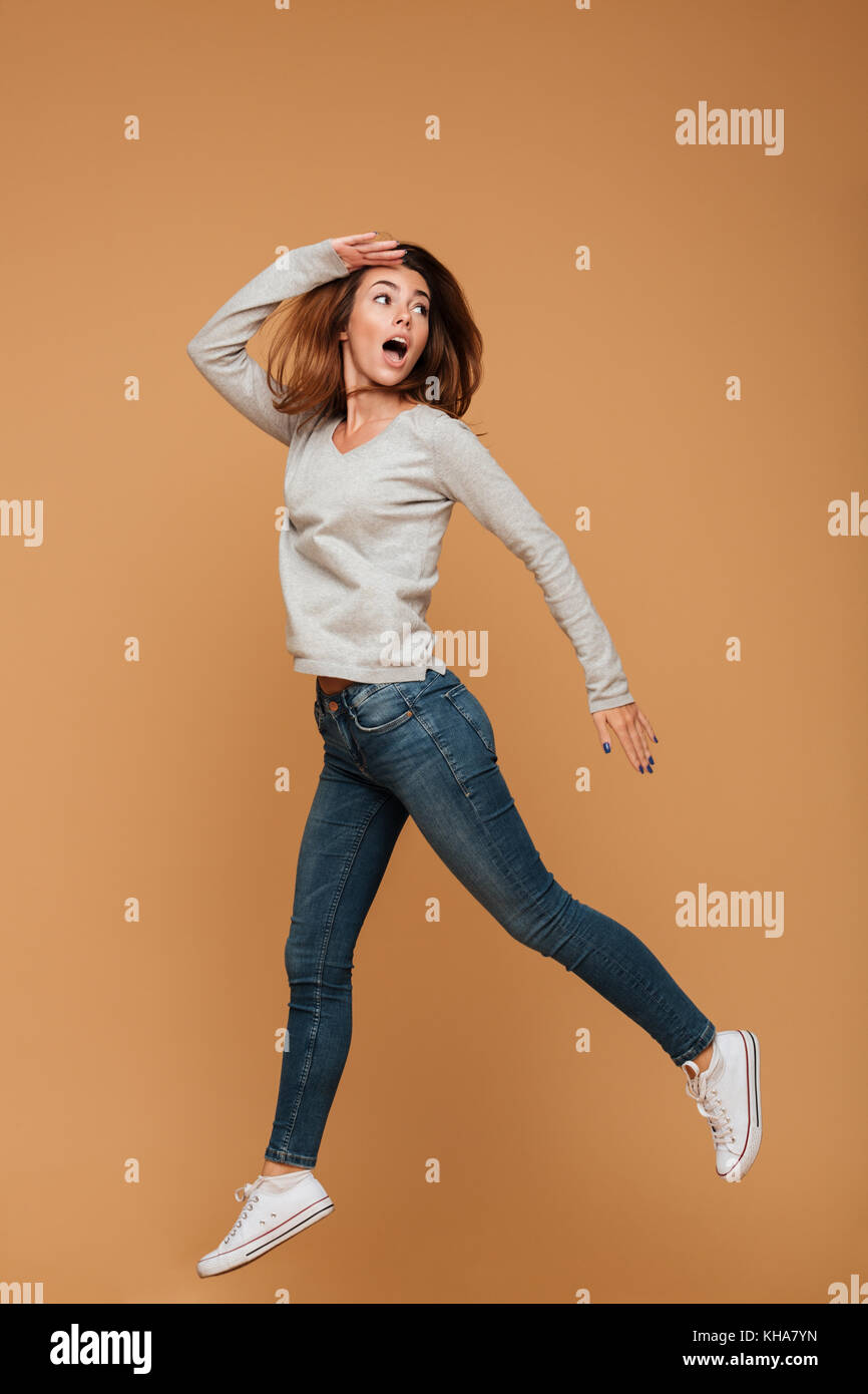 Image of screaming caucasian woman jumping isolated. Looking aside ...