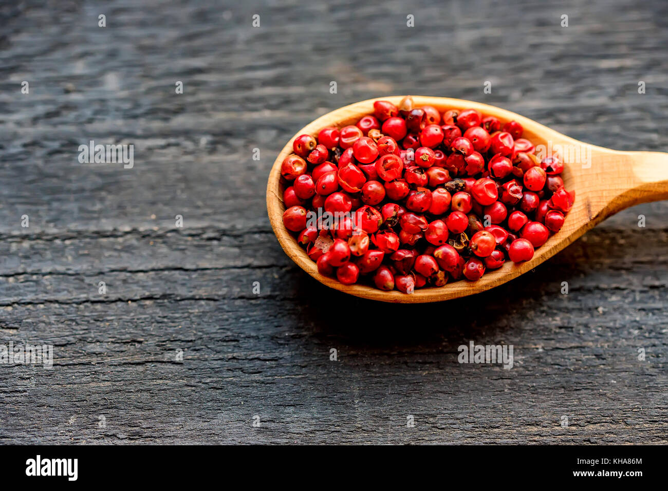 Pink peppercorn in wooden spoon studio shot Stock Photo - Alamy