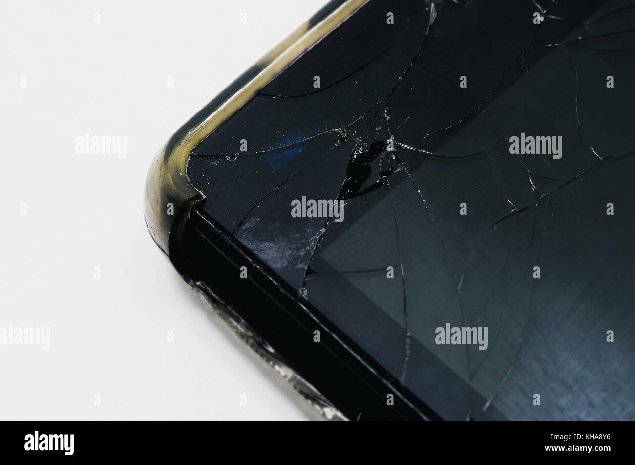 Close up on the upper corner of a smartphone with the glass broken of ...