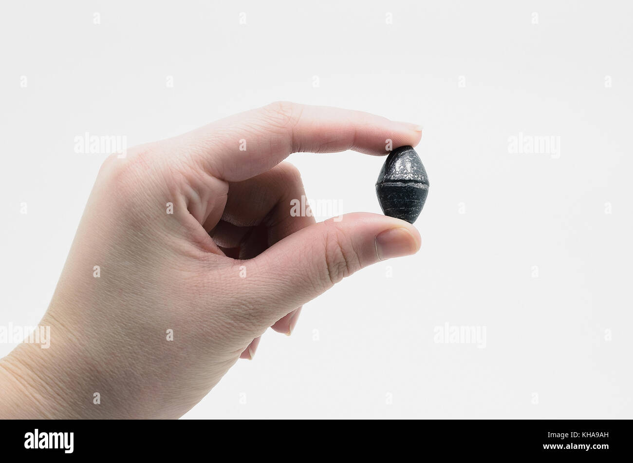 Holding a lead weight sinker used to sink lines for fishing on the ...