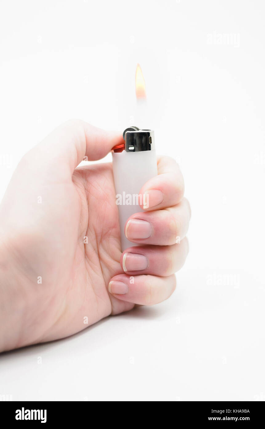 Hand lighting a lighter, fire coming out of the lighter Stock Photo - Alamy