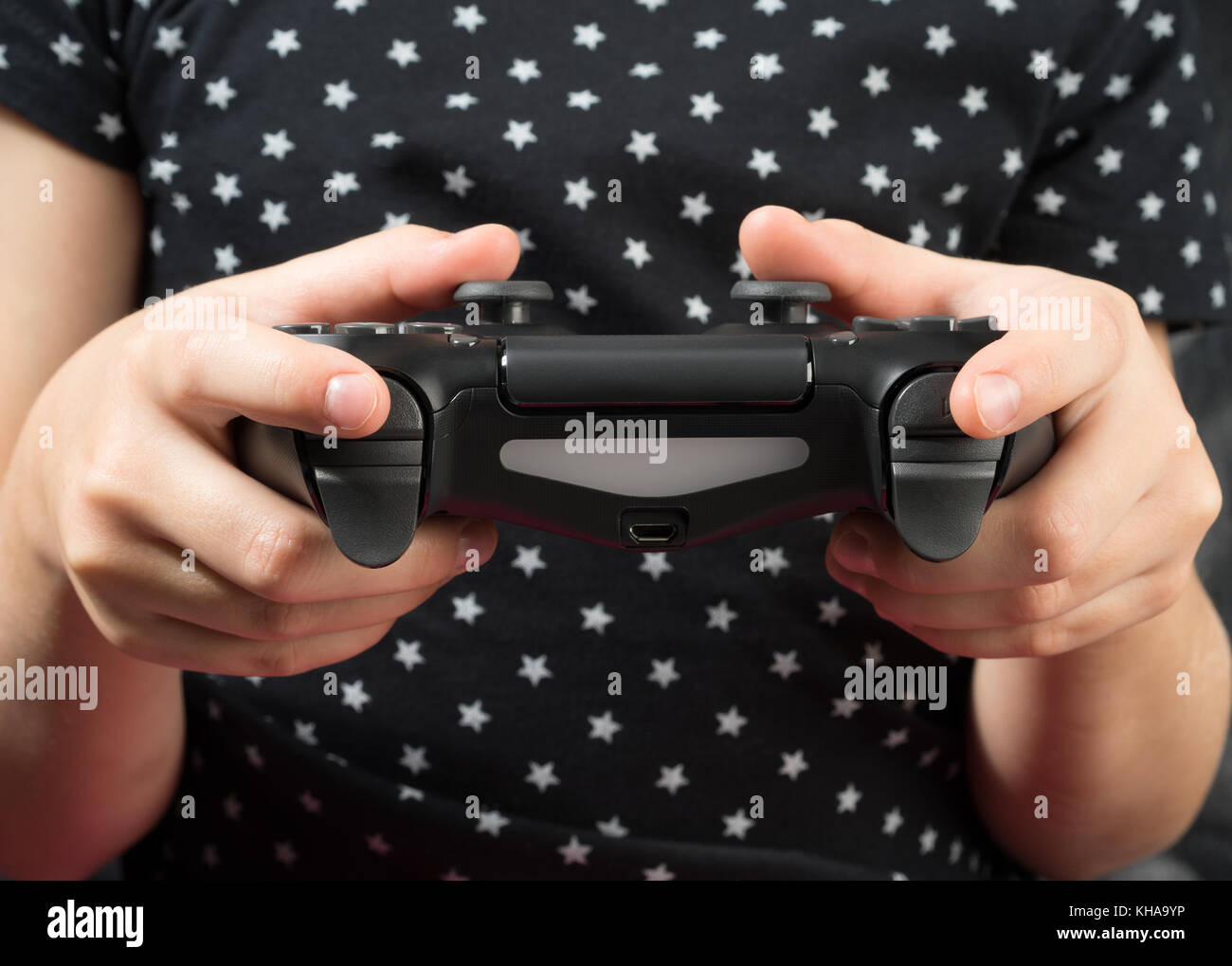 Child girl is playing video games and holds joystick or controller ...