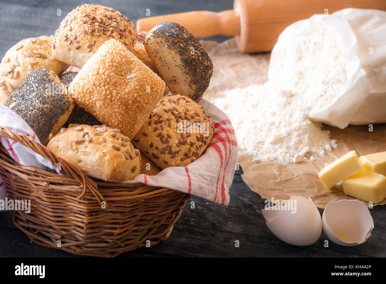 Baking theme image with a wicker basket full of homemade bread rolls ...