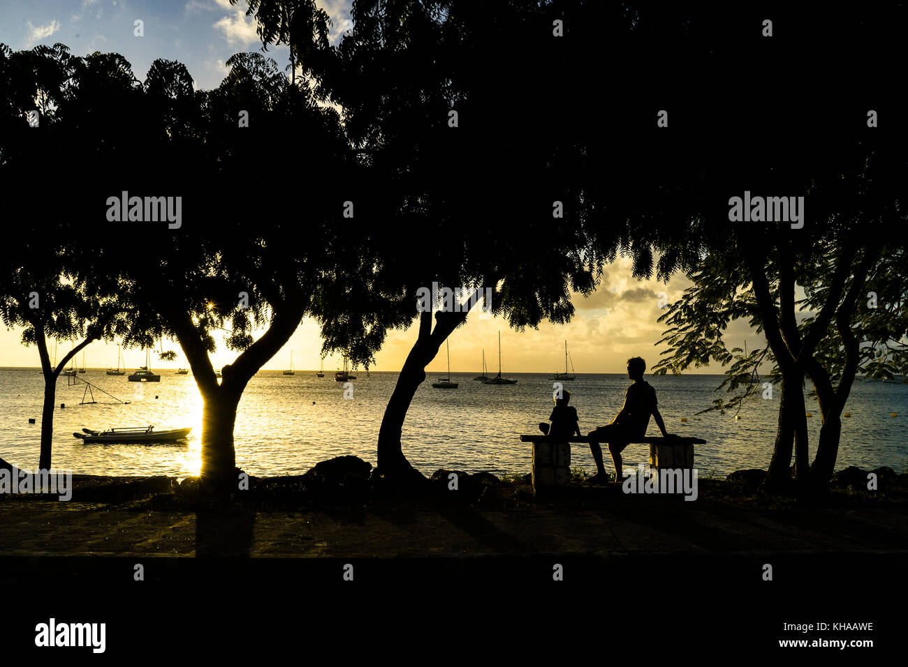 A father and his son sitted in front of the sunset, Saint-Louis, Marie ...