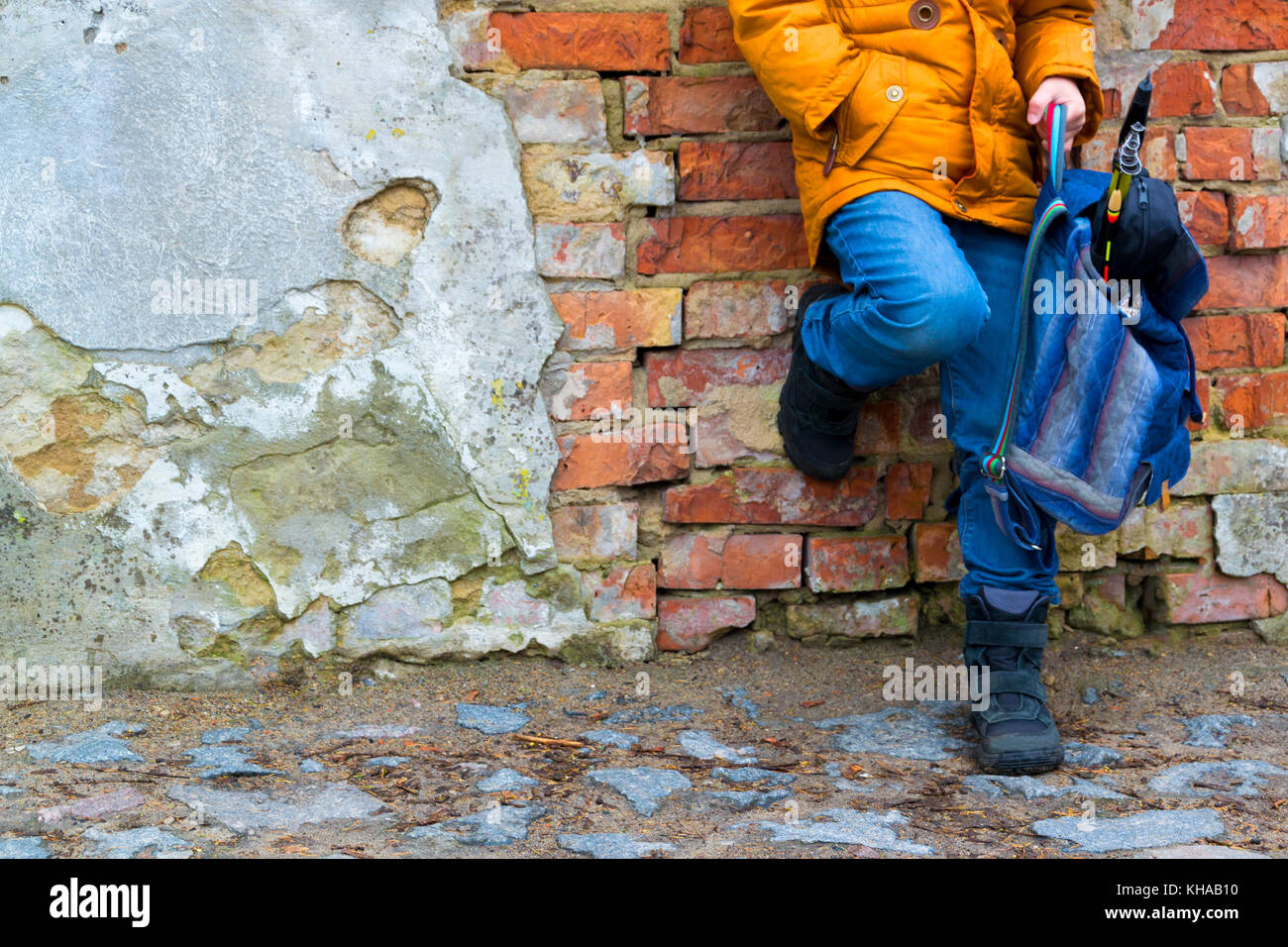 Kid boy legs and backpack against the wall Stock Photo - Alamy