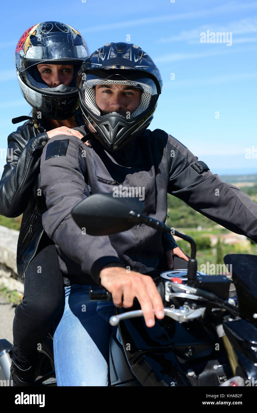 Happy young biker couple riding motorbike in summer Stock Photo - Alamy