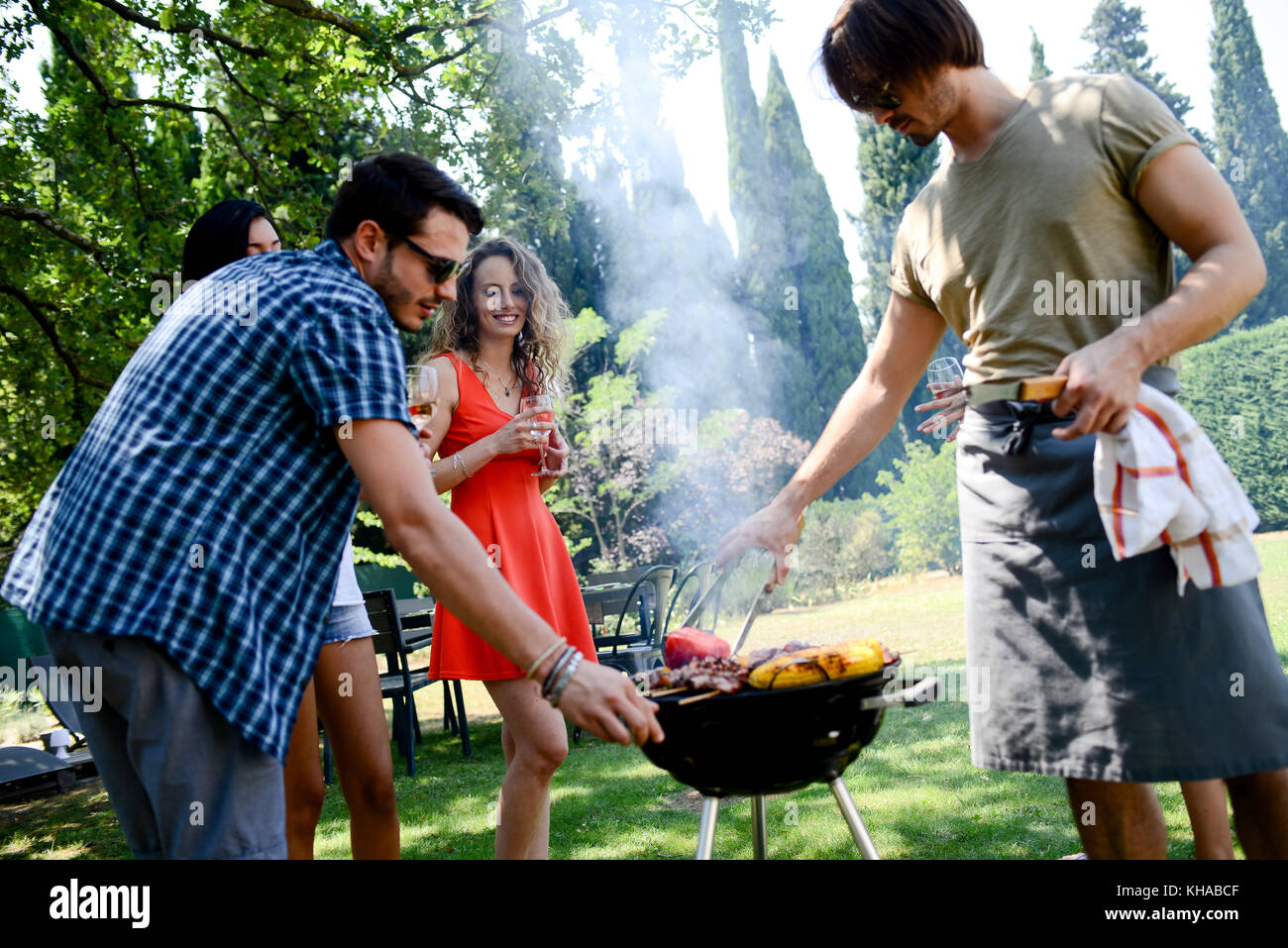 Groupe of happy and cheerful young people having fun around barbecue ...