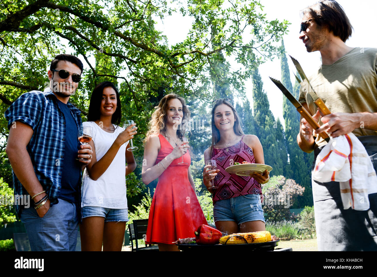Groupe of happy and cheerful young people having fun around barbecue ...
