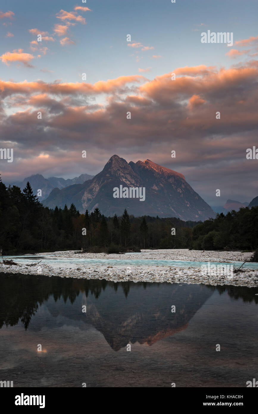 River course of the Soca River with Svinjak Mountain with evening mood ...