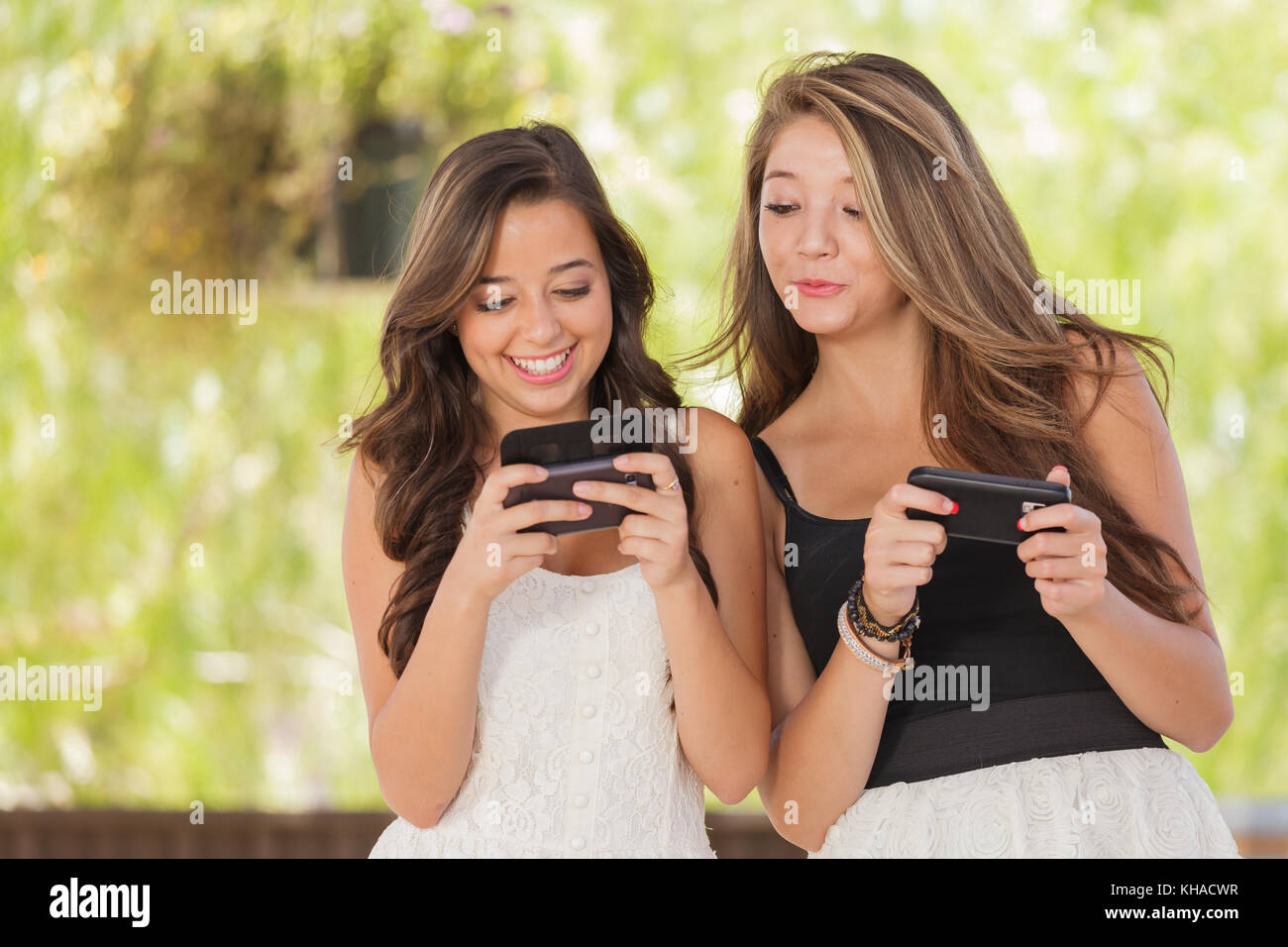 Two Expressive Mixed Race Girlfriends Using Their Smart Cell Phones