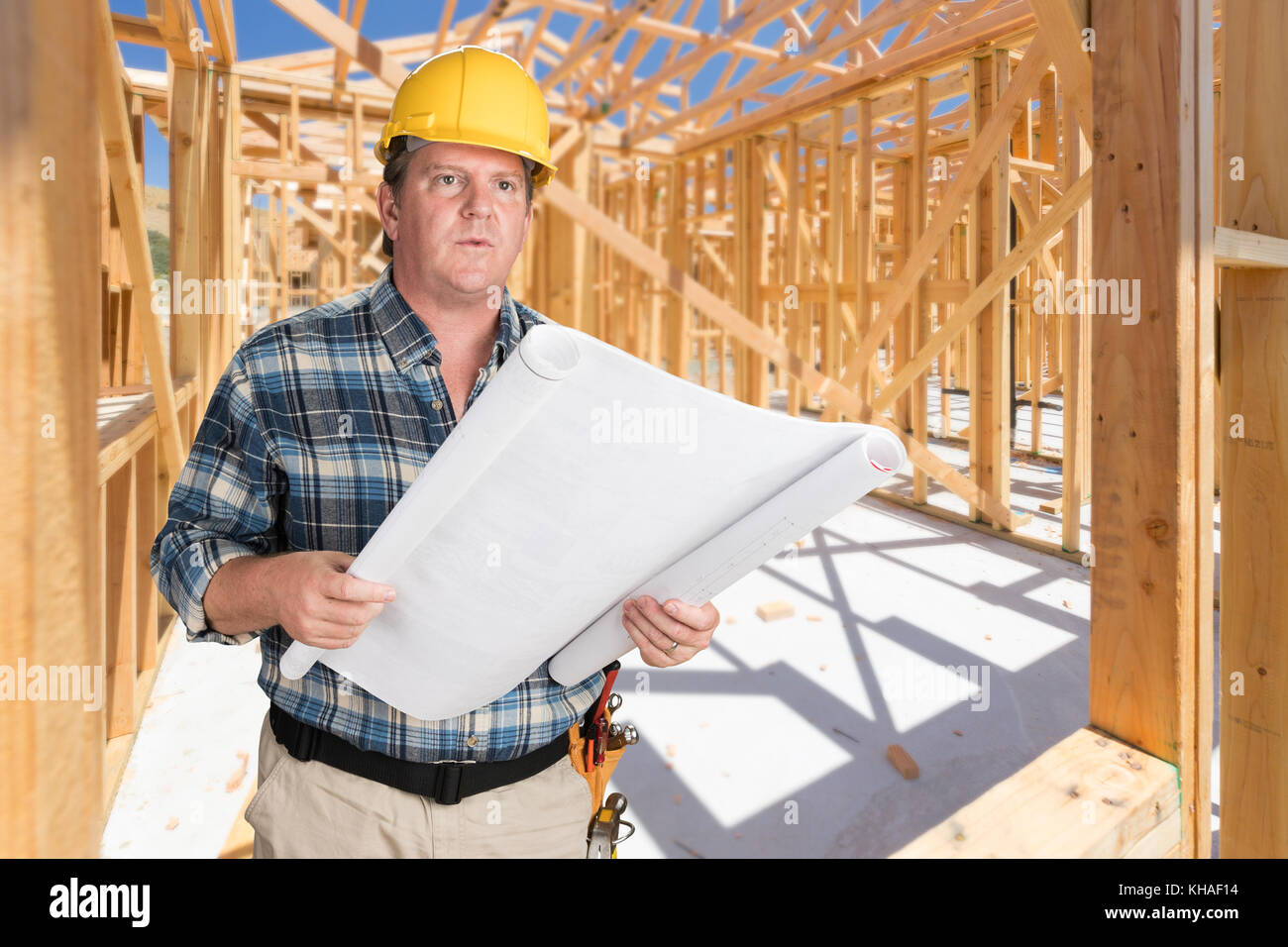 Male Contractor With House Plans Wearing Hard Hat Inside New House ...