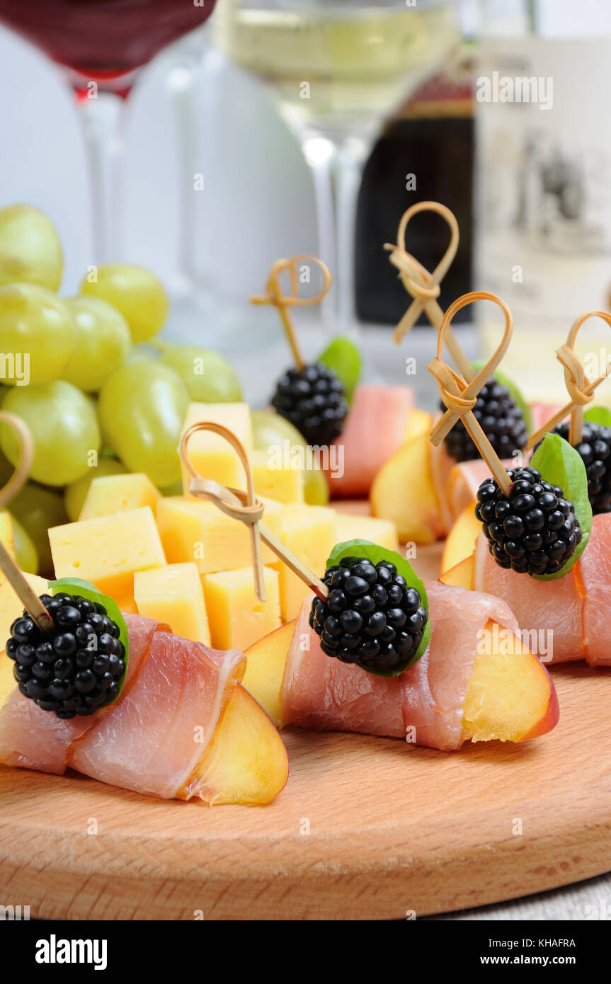 Canape from peach with dried ham and blackberries Stock Photo - Alamy