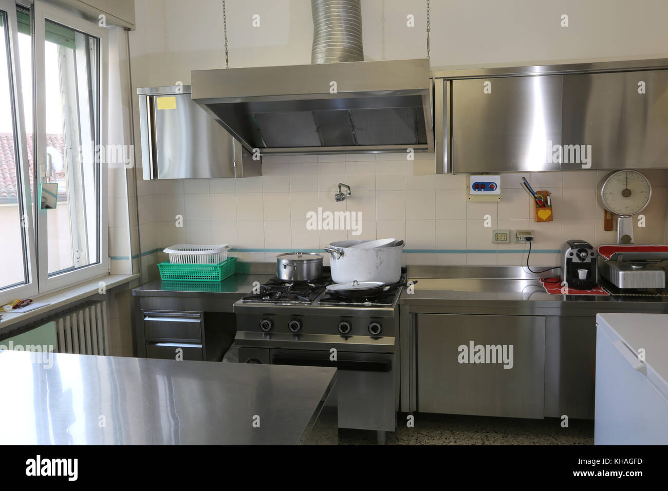 inside a Commercial Industrial Kitchen with furniture in stain steel ...