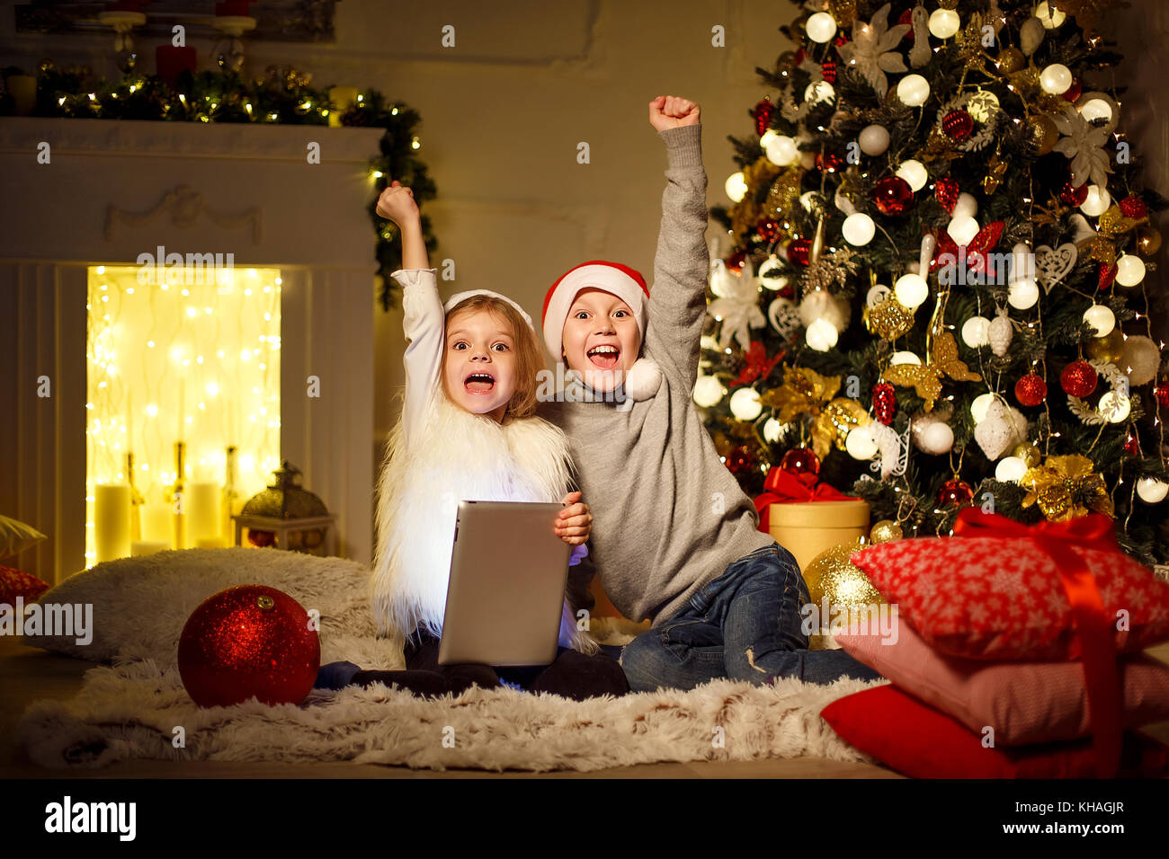 Excited children near Christmas tree Stock Photo - Alamy
