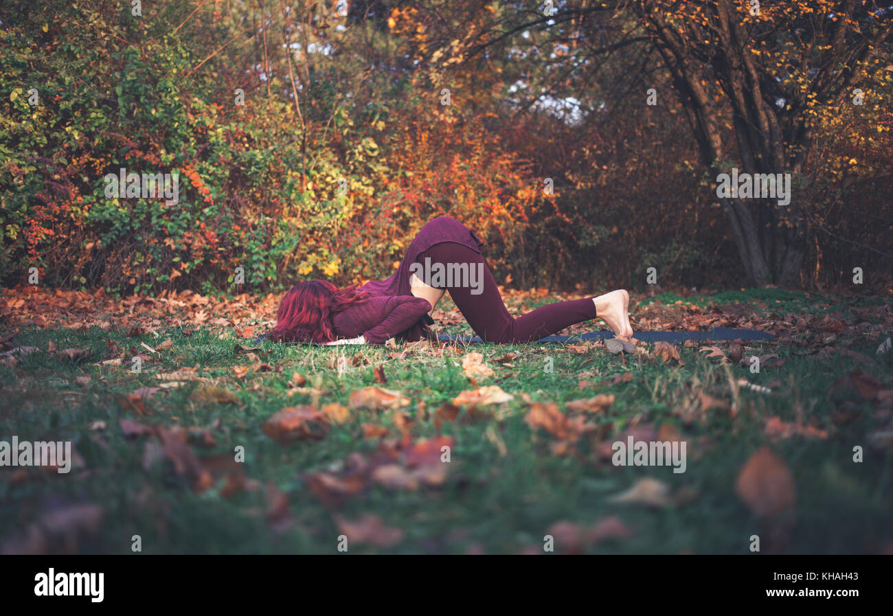 Girl on a bright autumn day practicing yoga outdoors, doing eight ...
