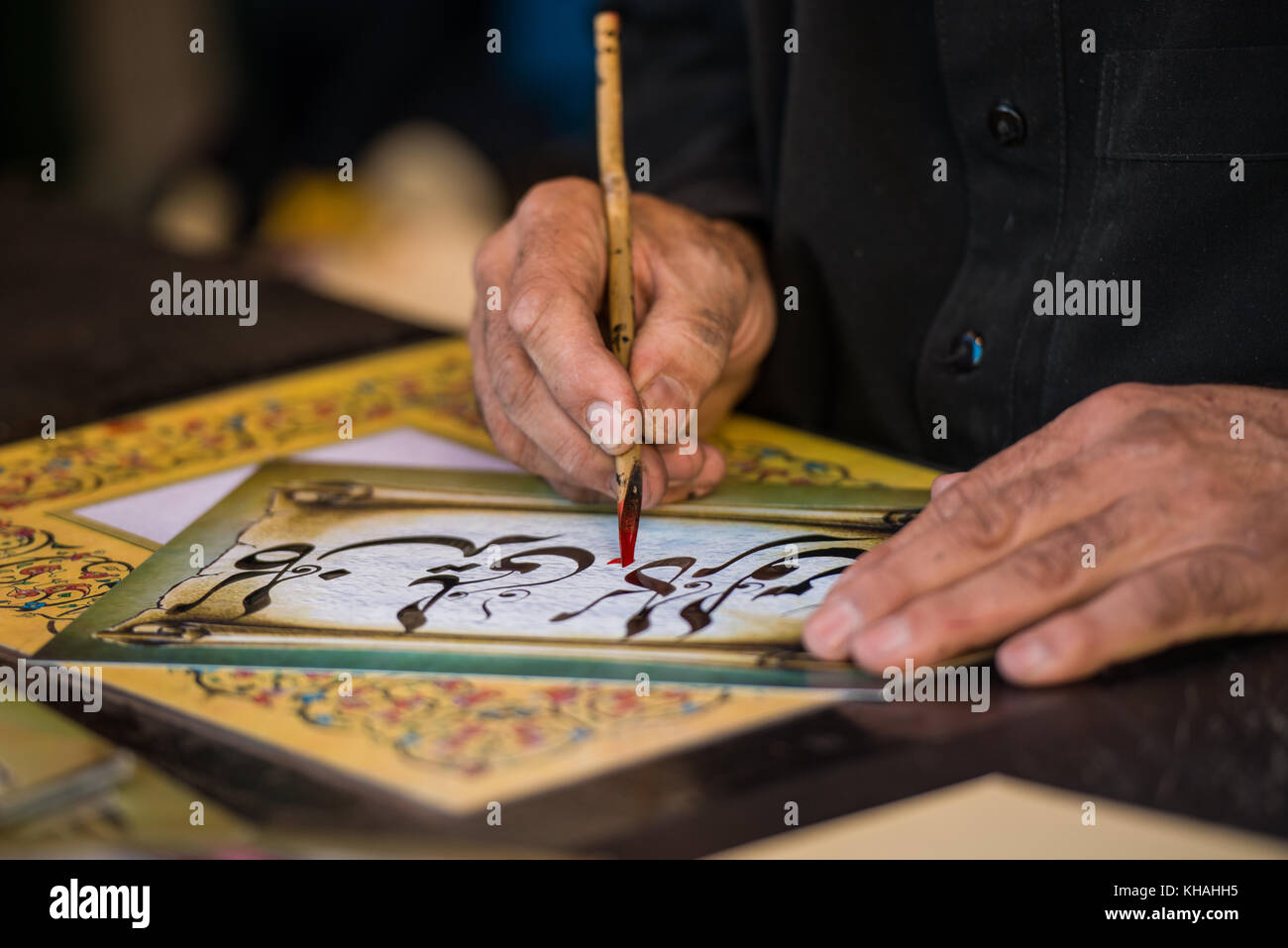 The hands of an old man writing letters with Arabic spelling Stock ...