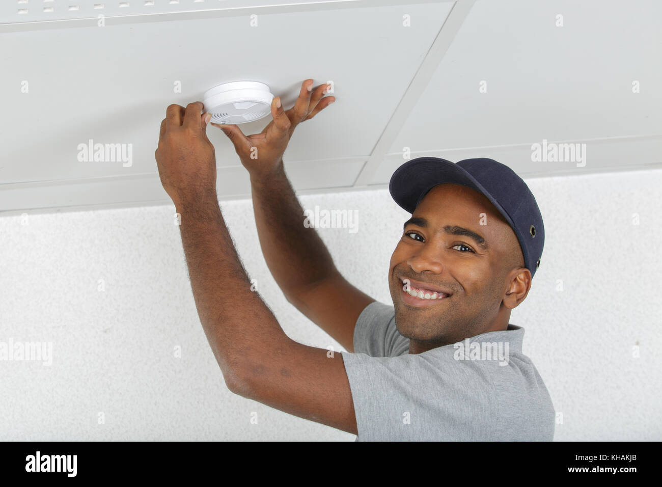 Man fitting smoke detector Stock Photo - Alamy