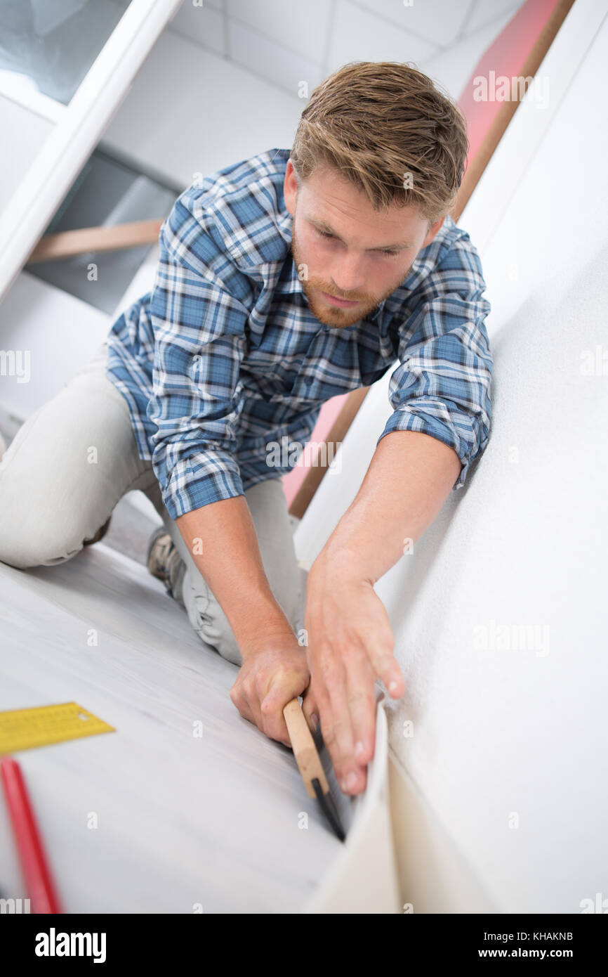 craftsman fitting carpet on floor Stock Photo - Alamy