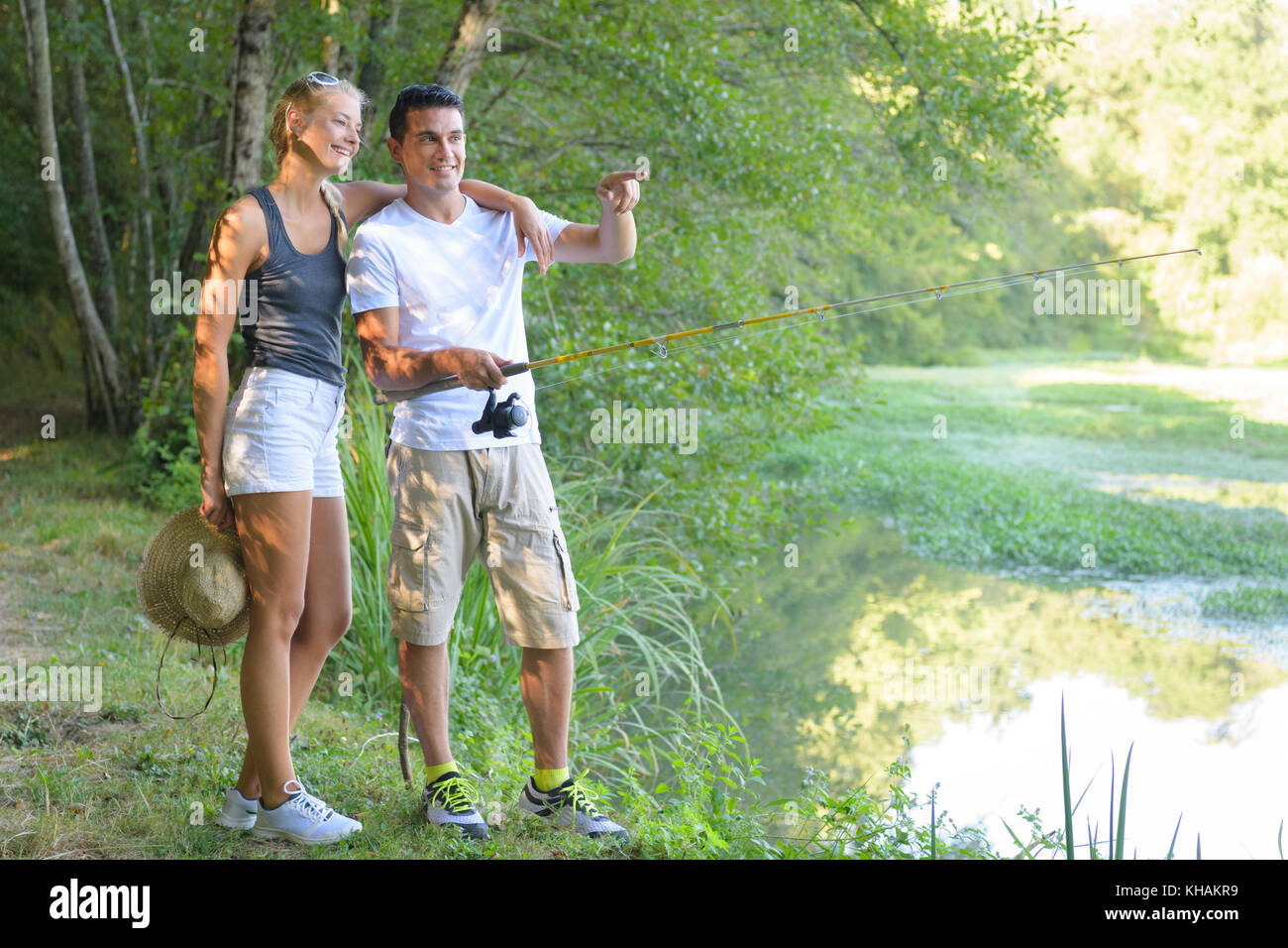 peaceful young couple fishing by the pond in autumn Stock Photo - Alamy