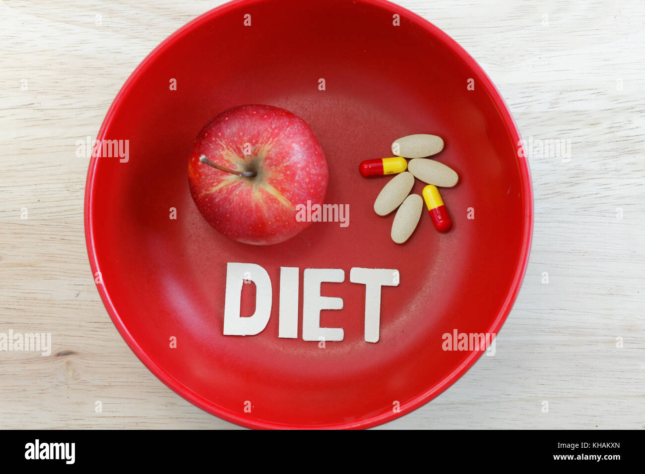 Red bowl, an apple, pills and word DIET. Concept of diet, nutrition ...