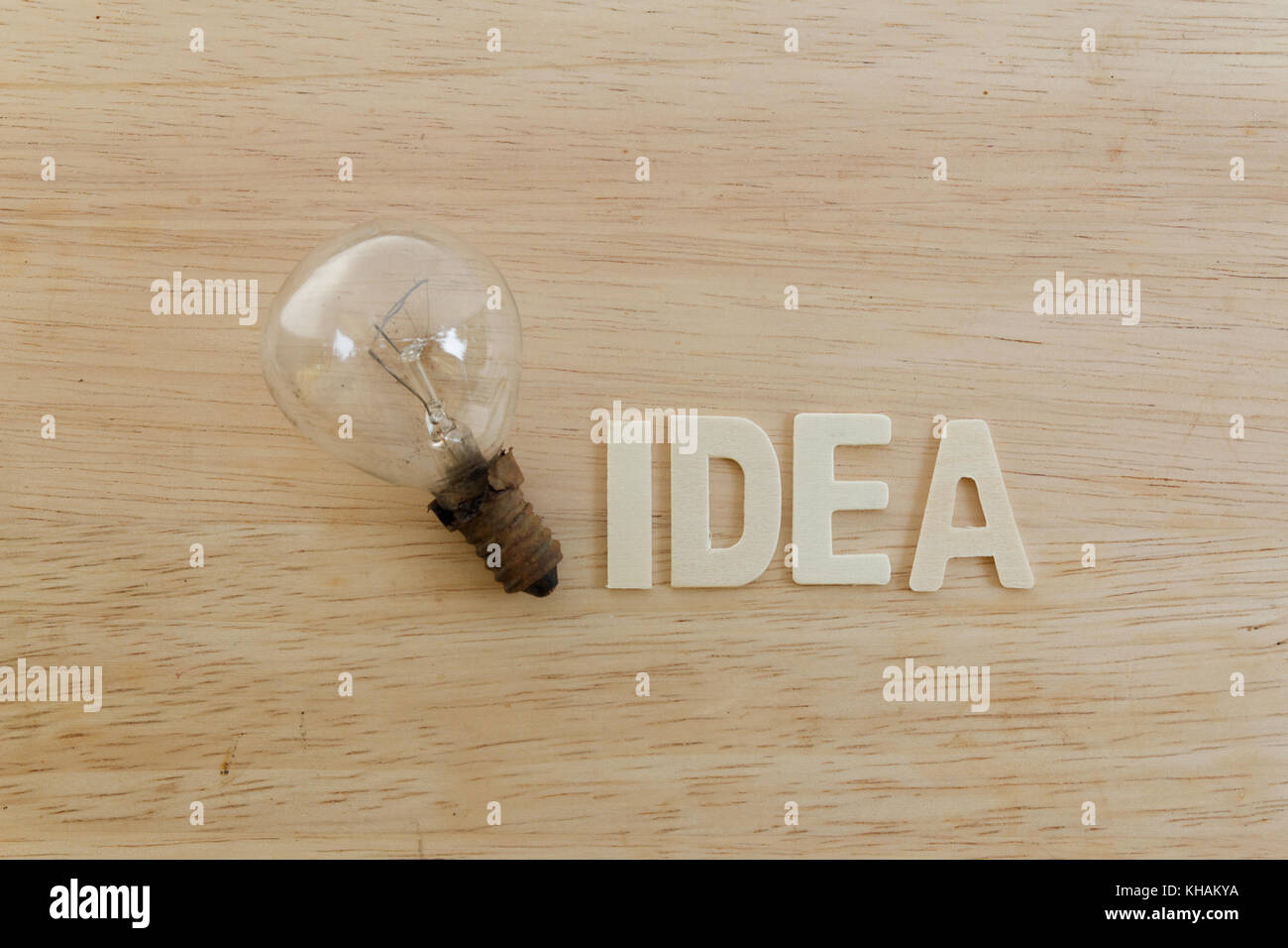 Rusty light bulb on wooden background with text IDEA. Concept of idea ...