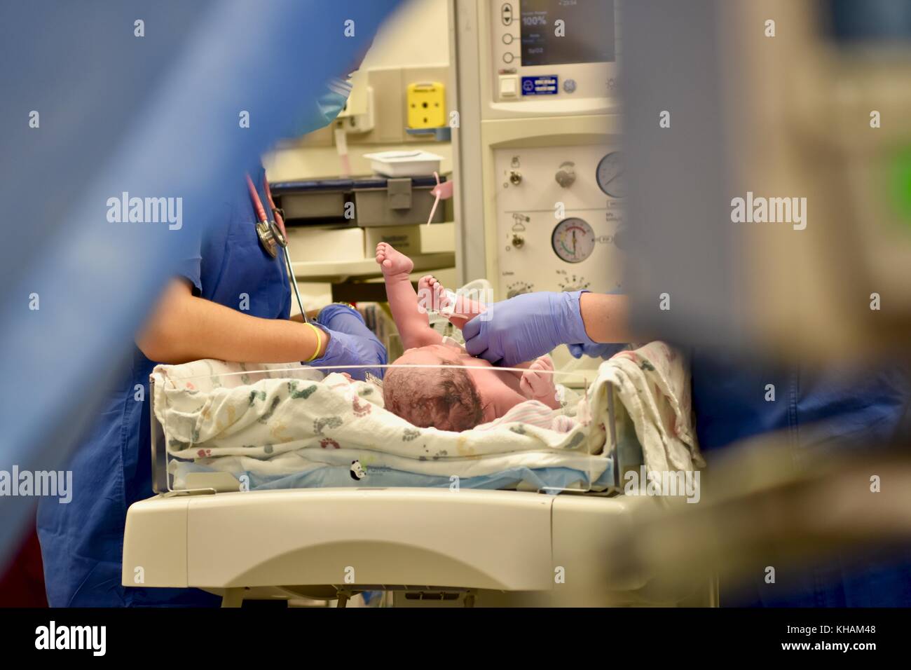 Newborn baby being checked out by the medical staff immediately after ...