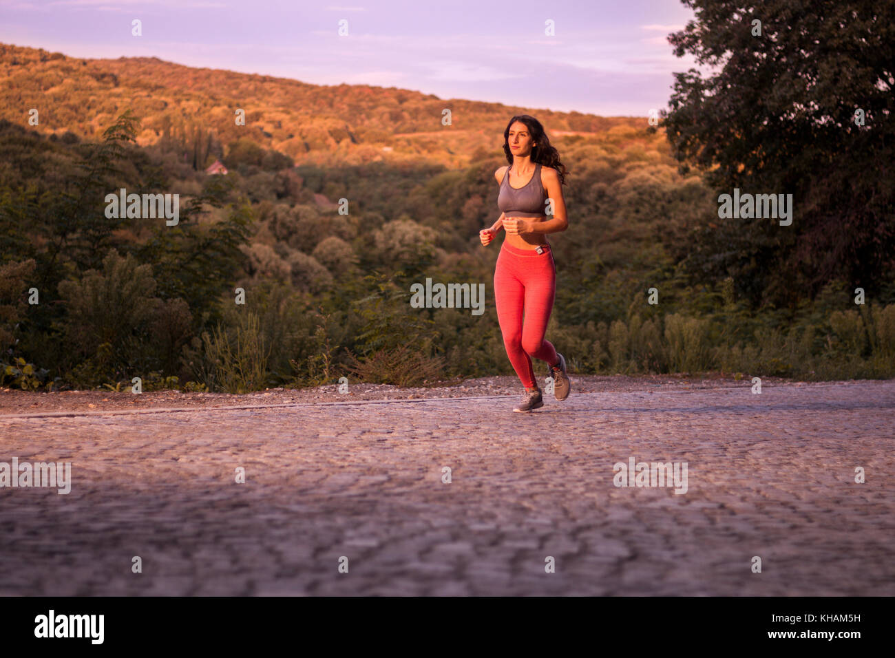 sunset sunrise, wood trees, running jogging, one young adult woman ...