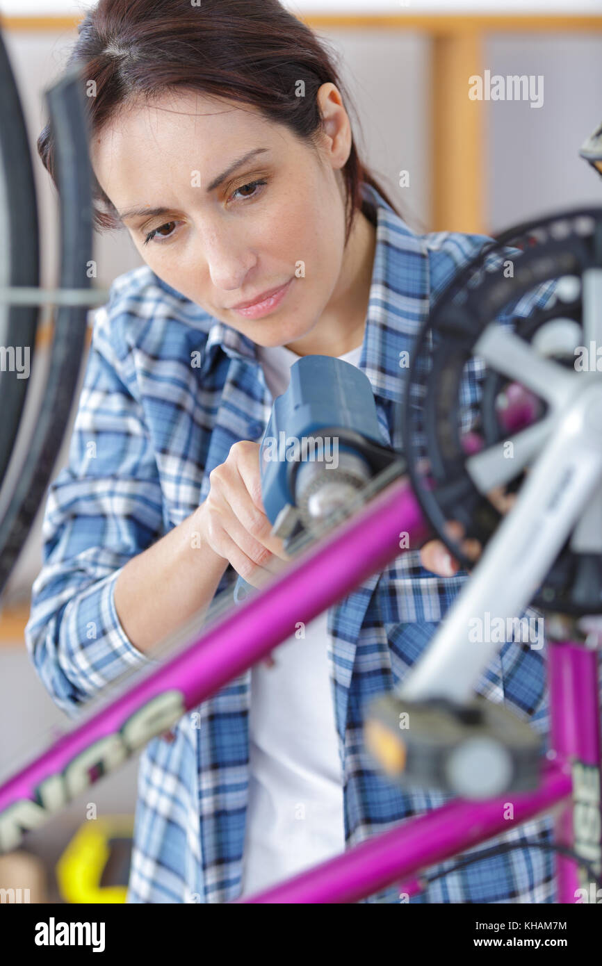 Woman working on bicycle pedal Stock Photo - Alamy