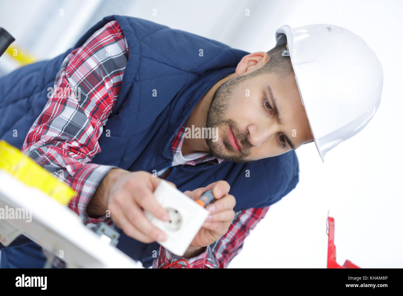 Workman using screwdriver on plug socket Stock Photo - Alamy