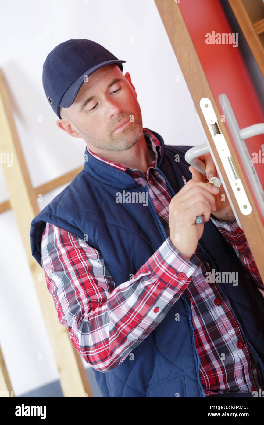 portrait young male carpenter repairing door lock Stock Photo - Alamy
