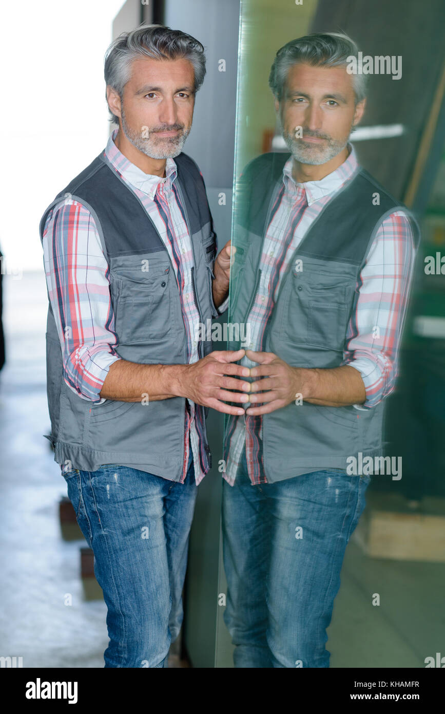 Man carrying glass, visible reflection of himself Stock Photo - Alamy