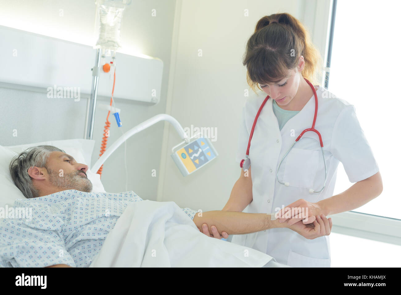 doctor examining patients pulse in hospital room Stock Photo - Alamy