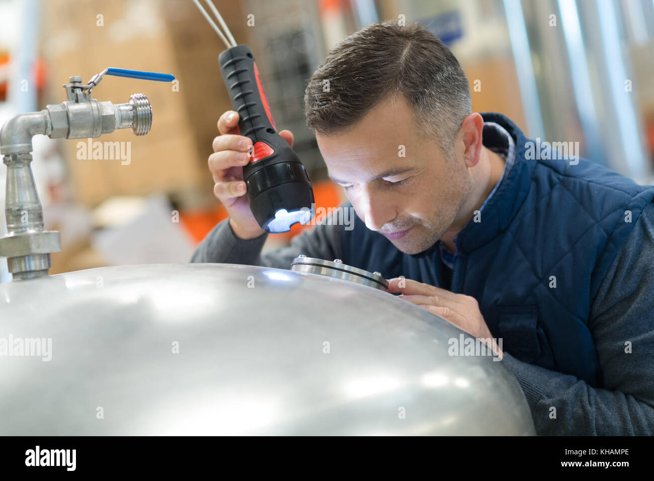man looking through a stainless container Stock Photo - Alamy