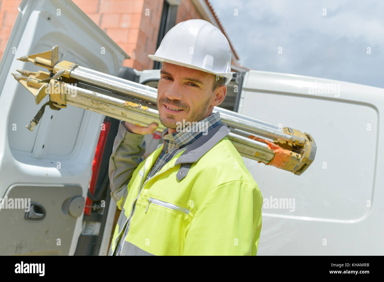 Surveyor holding tripod over his shoulder Stock Photo - Alamy