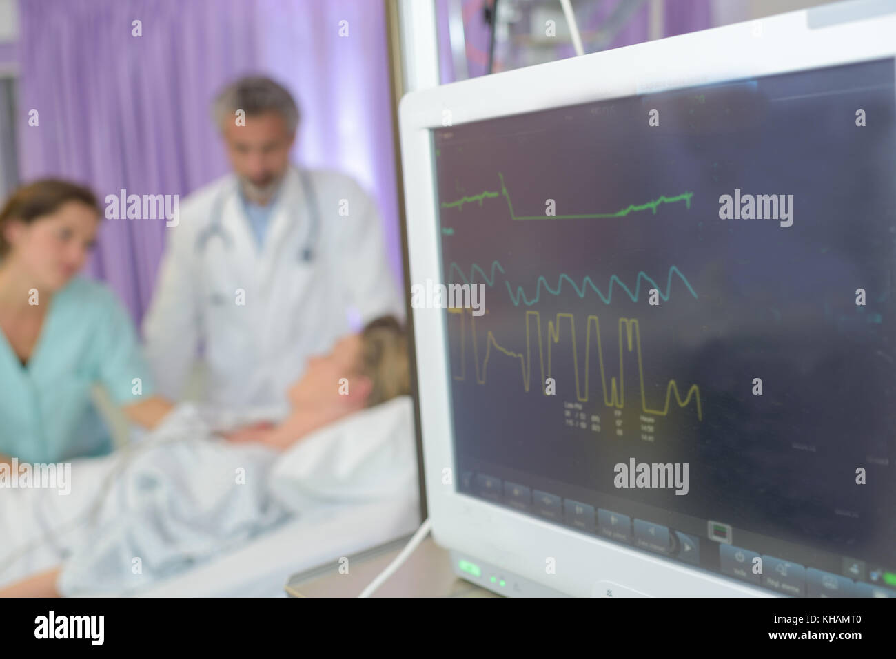 Monitor in foreground, patient in hospital bed in background Stock ...