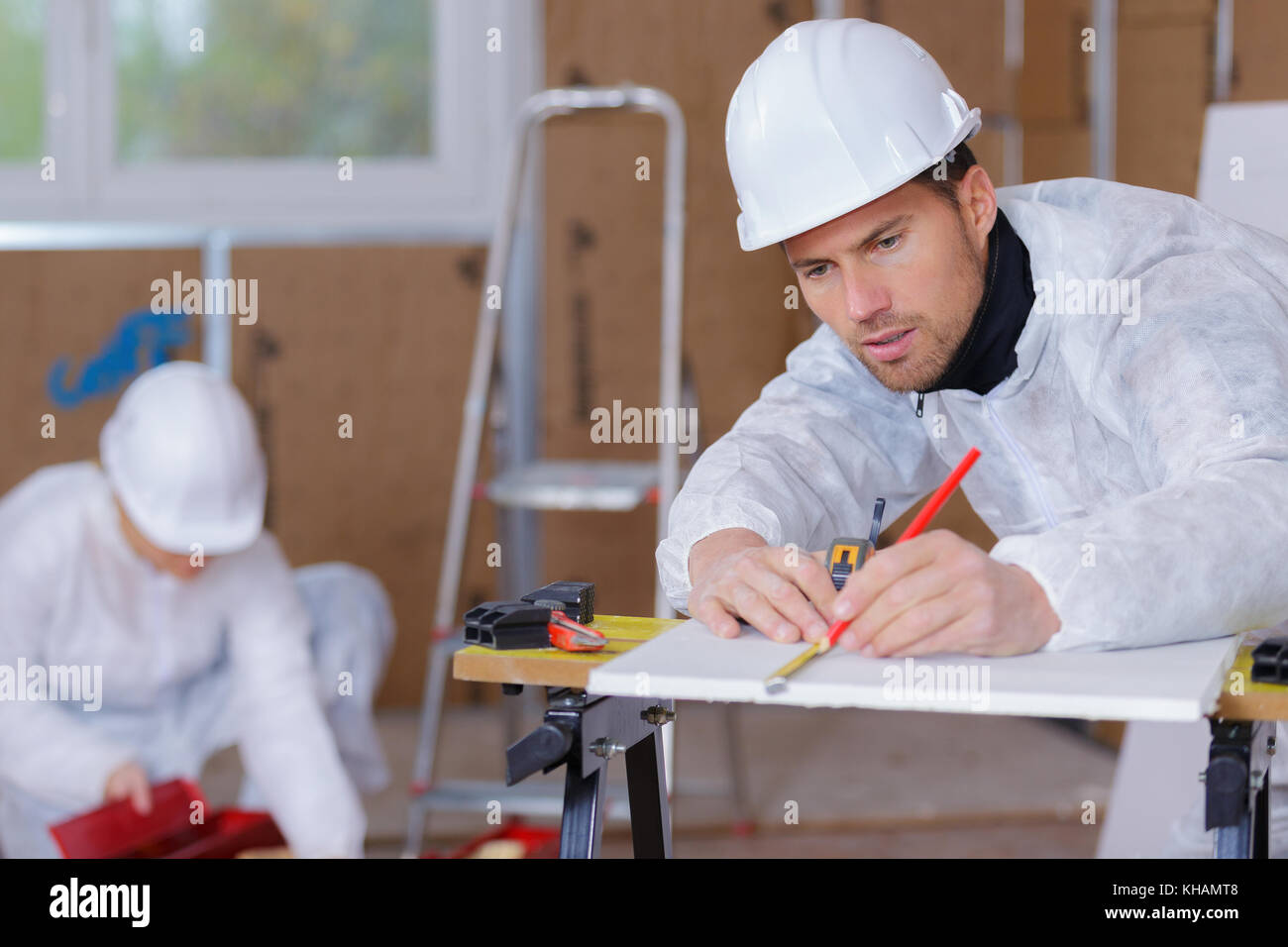 confident male carpenter measuring wooden plank in workshop Stock Photo ...