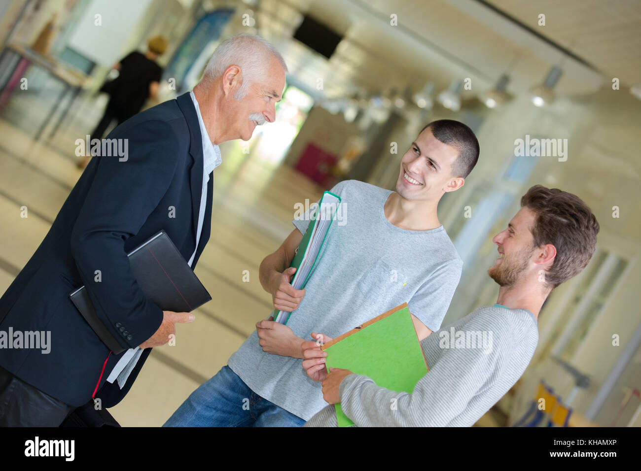 professor talking to students in the hallway Stock Photo - Alamy