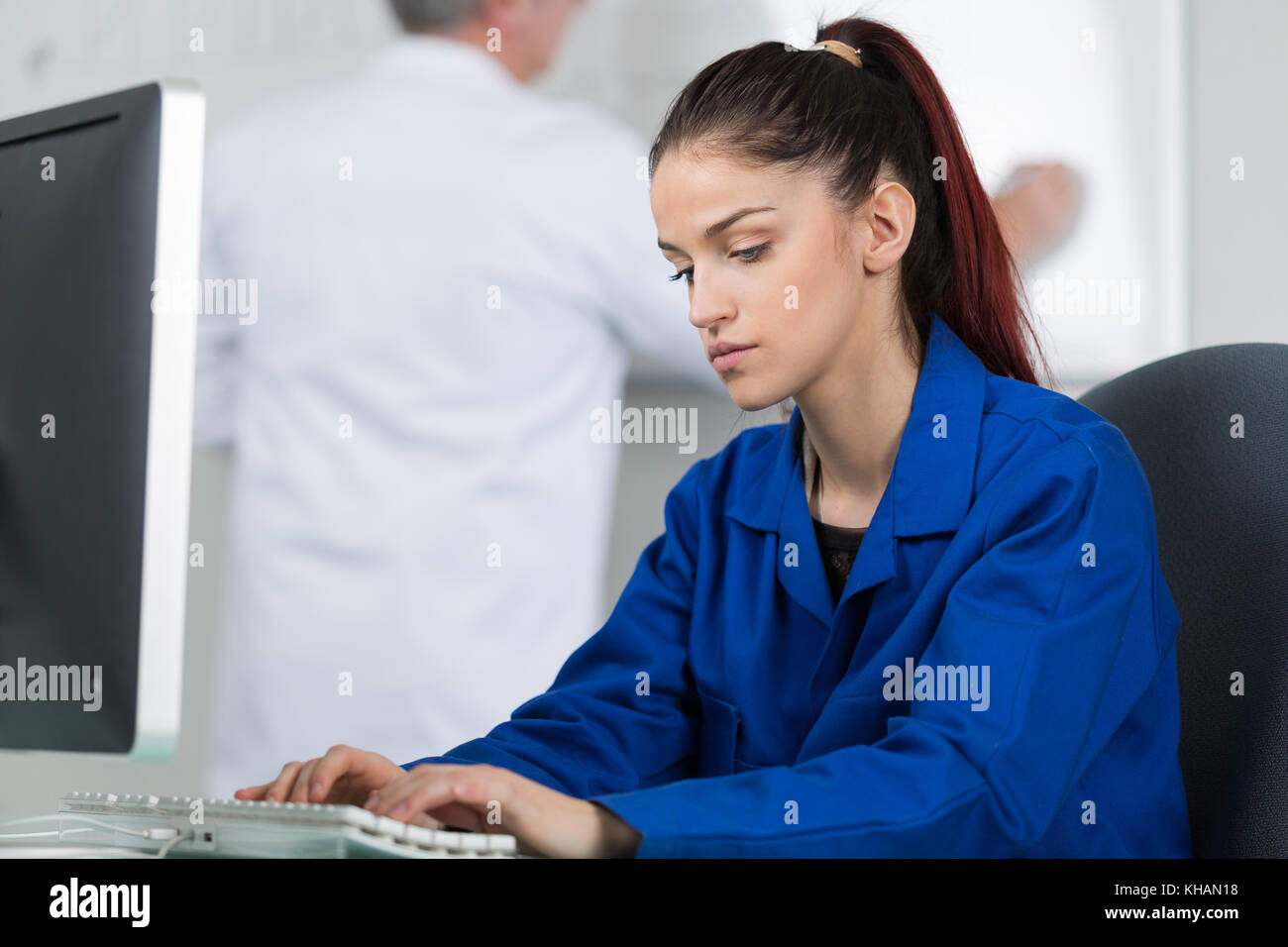 young technician wearing blue jacket typing on keyboard Stock Photo - Alamy