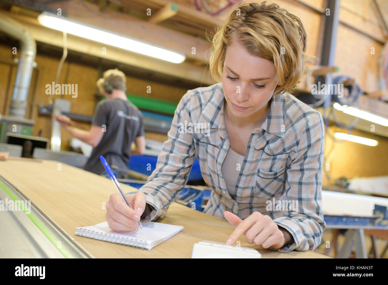 young woman construction worker writing on notebook Stock Photo - Alamy