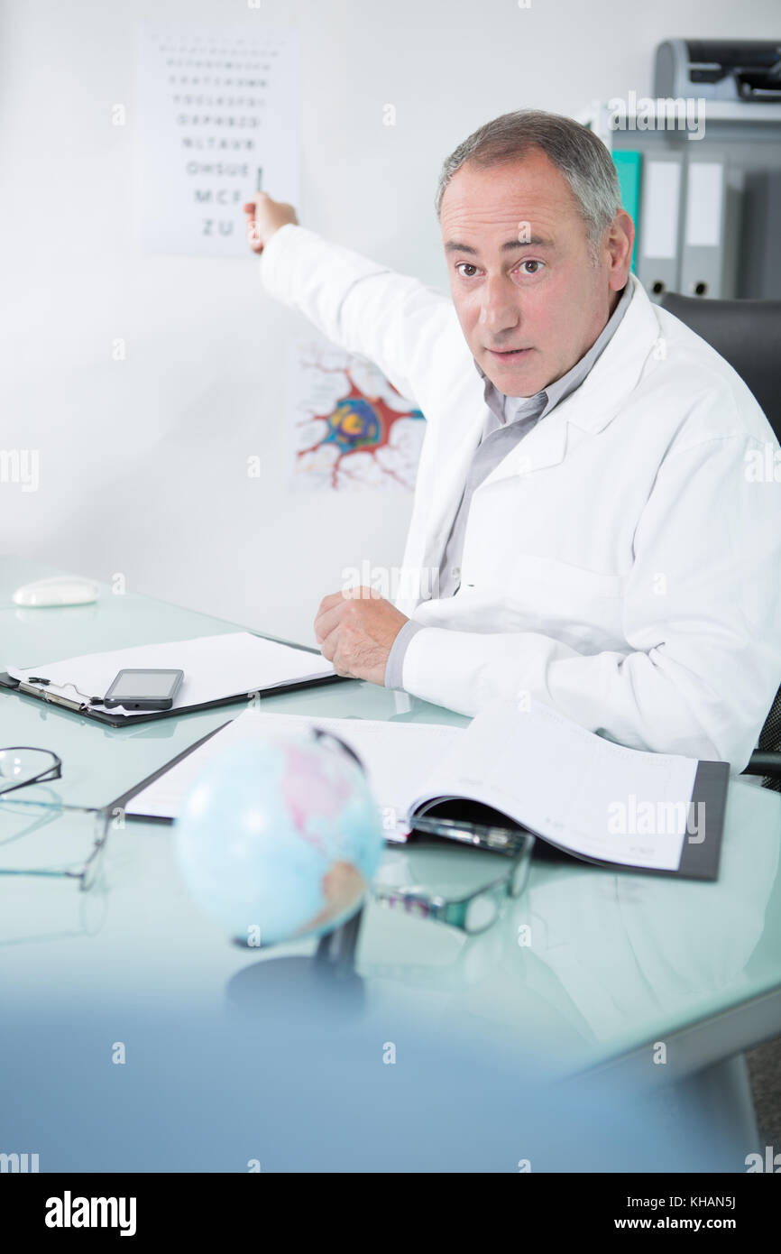 doctor showing optician test to patient Stock Photo - Alamy