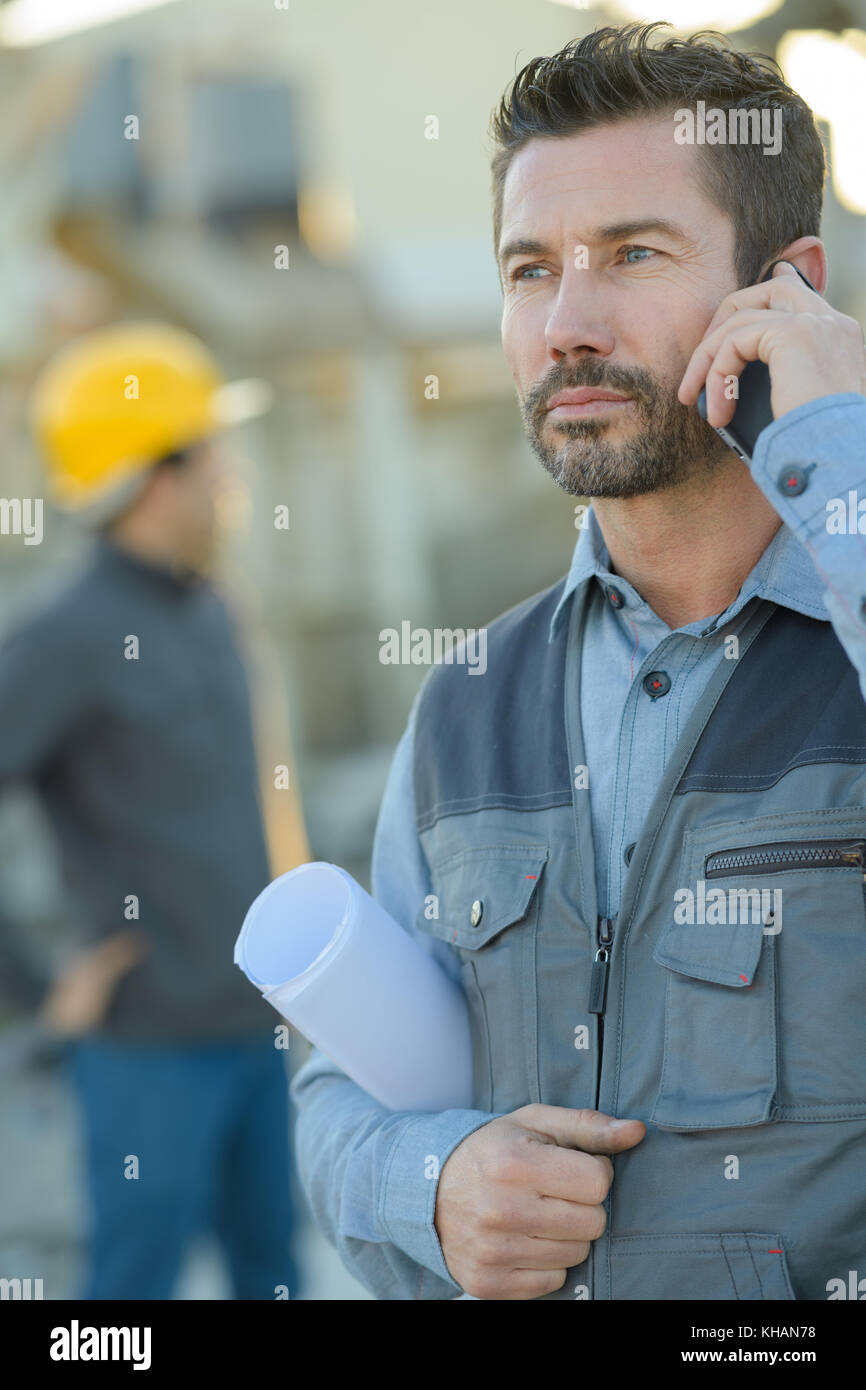 building contractor working on site standing phoning Stock Photo - Alamy