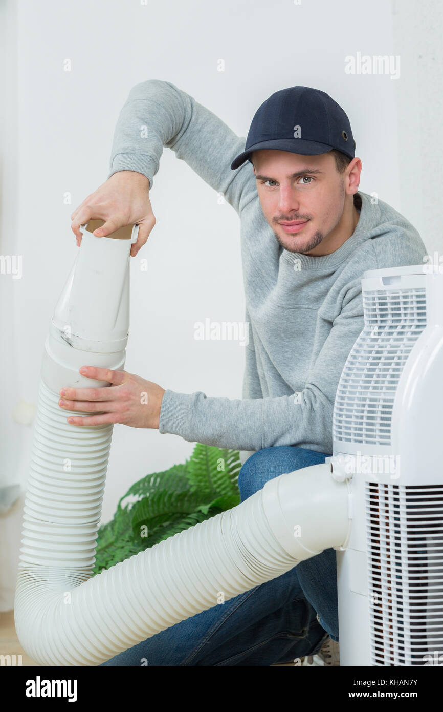 Man working on hose of air conditioning unit Stock Photo - Alamy
