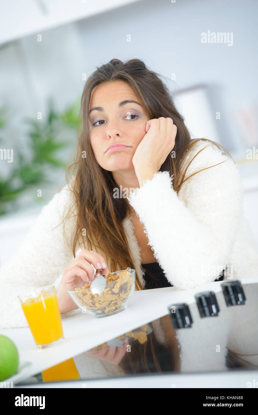 Bored woman having breakfast Stock Photo - Alamy