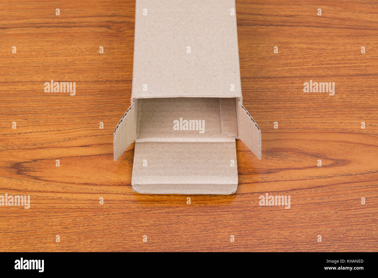 Empty opened brown cardboard box or tray for mock up on bright wooden ...