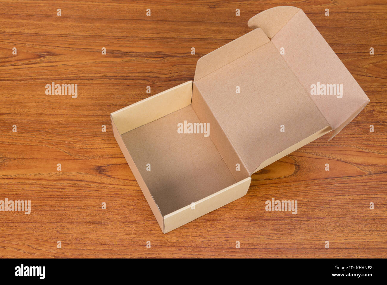 Empty opened brown cardboard box or tray for mock up on bright wooden ...