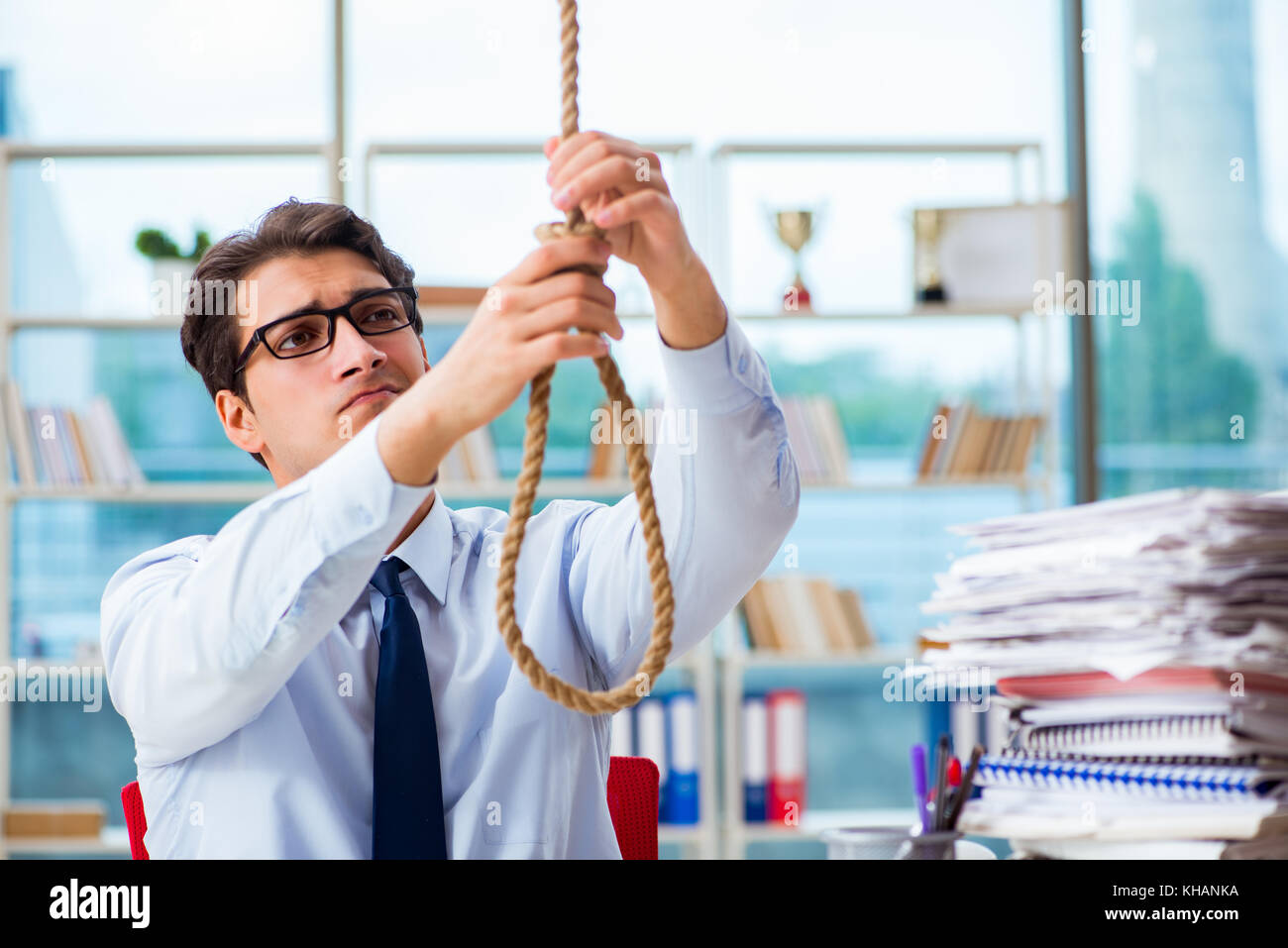 Unhappy businessman thinking of hanging himself in the office Stock ...