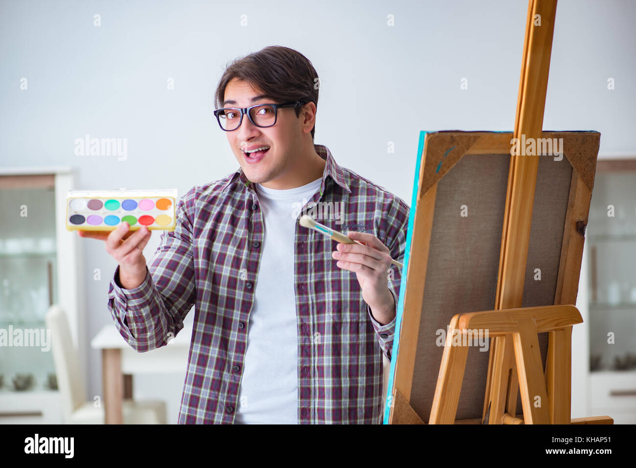 Young male artist drawing pictures in bright studio Stock Photo - Alamy