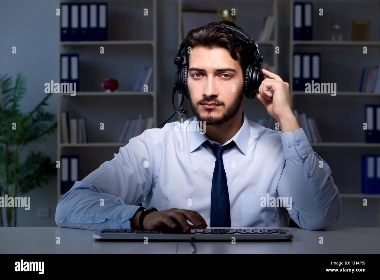 Young man in call center concept working late overtime in office Stock ...